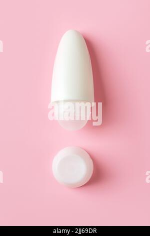 White cosmetic tube, roll pink and gold ribbons on pink background ...