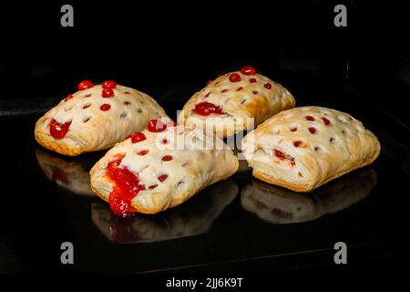 Four baked homemade buns with red strawberry jam in electric oven Stock ...