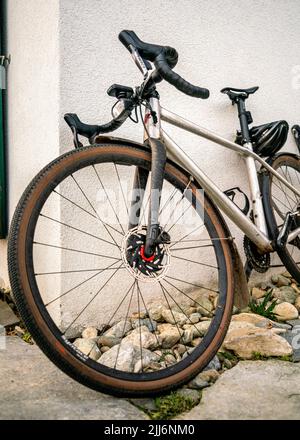 Vertical shot of a bicycle leaning against a tree in a lush green ...