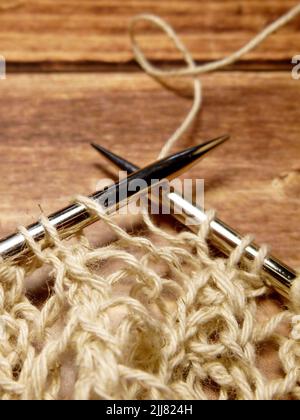Openwork tablecloth in the process of knitting. Knitting needles, loops ...
