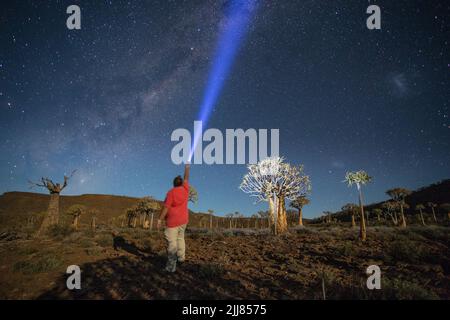 Caucasian man pointing flashlight at night sky Stock Photo - Alamy