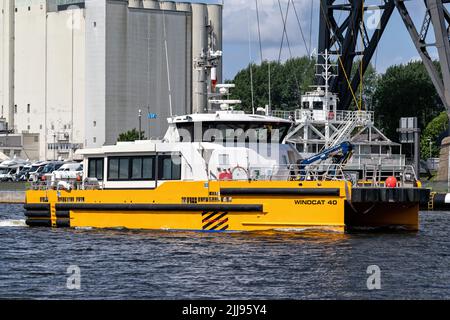 Offshore wind farm, crew transfer vessel docked on landing station ...