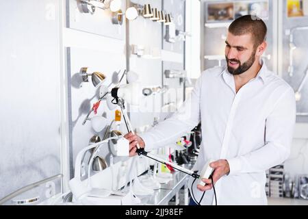 man trying to use desk lamp Stock Photo - Alamy