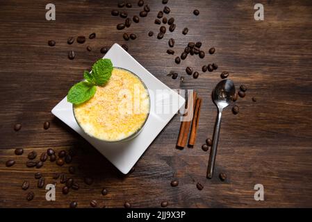 Dessert classic tiramisu view from above, garnished with mint leaves ...