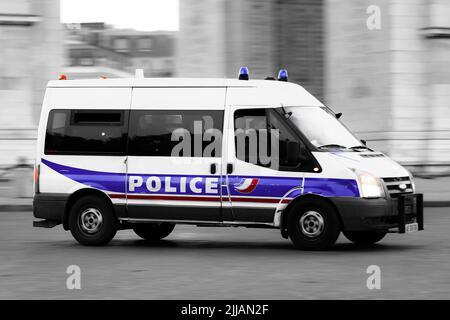 A police car (truck, van) drives through the city ensuring security in ...