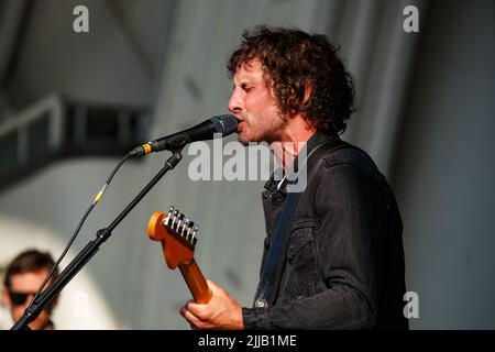 Sam Roberts plays guitar and sings on stage wearing a denim jacket and ...