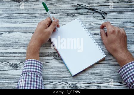 Man writing in notepad mock up, using his left hand. Conceptual photo ...