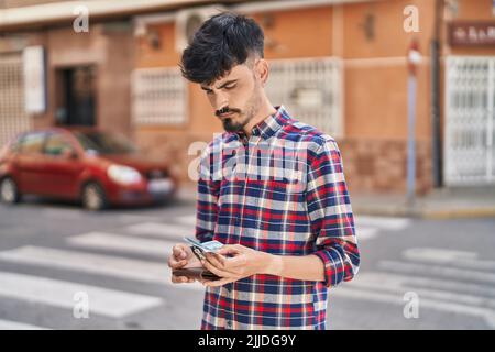 Young hispanic man counting dollars at street Stock Photo - Alamy