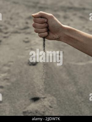 Man pouring sand through hand in desert Stock Photo - Alamy