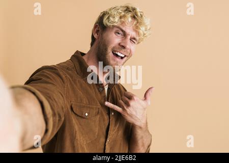 White blonde man gesturing while taking selfie photo isolated over ...