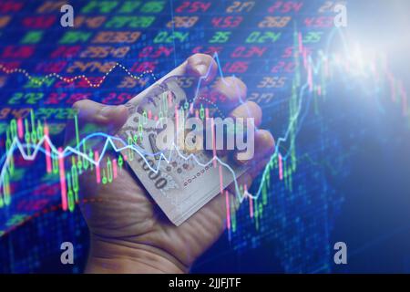 money Thai 1000 baht banknotes in hand. and stock chart trading ...