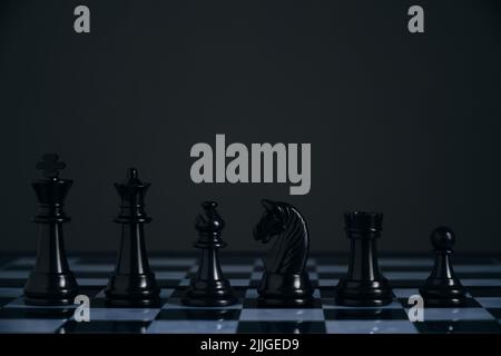 All suits black chess pieces on chess board Stock Photo - Alamy