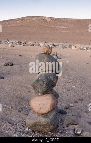 Rock cairns built by visitors at the prehistoric Giant of the Atacama ...