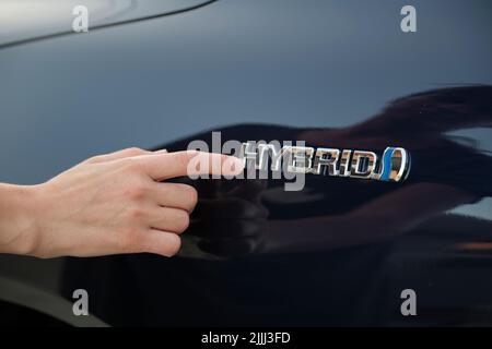 Human hand showing hybrid car sign on new effective vehicle Stock Photo ...