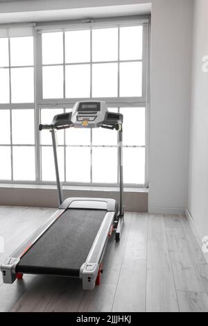 Modern treadmill near window in room, closeup Stock Photo - Alamy