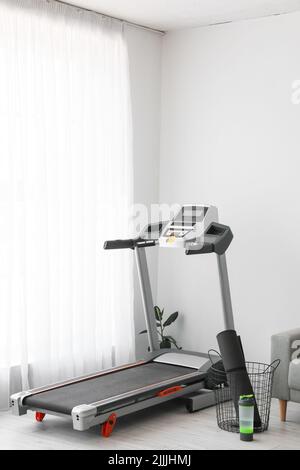 Interior of light living room with treadmill and sofa Stock Photo - Alamy