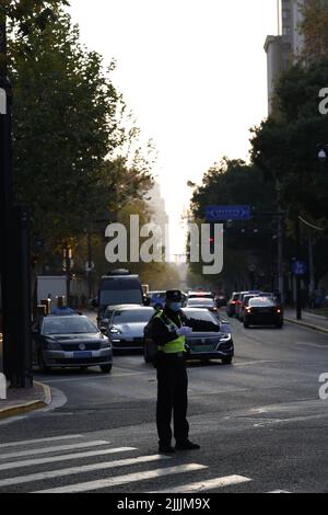 A police officer controlling traffic with a lot of cars in Shanghai ...