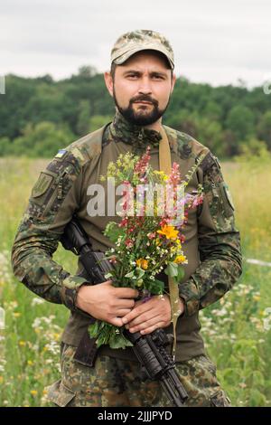 A Ukrainian soldier with a bouquet of wild flowers as a symbol of ...