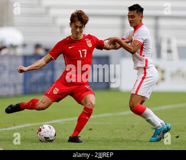 Law Tsz-Chun (7) of Hong Kong vies for the ball with Glenn Kweh Jia Jin ...