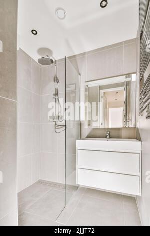 Sinks with mirrors and shower box with glass door in modern bathroom ...