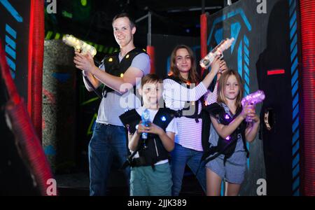 Parents and children playing laser tag Stock Photo - Alamy
