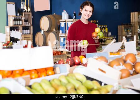 Portrait of young customer selecting apple in grocery Stock Photo - Alamy