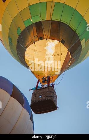 A vertical shot of a blue hot air balloon on a clear sky background ...