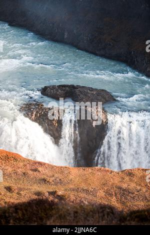 A vertical shot of the Gullfoss waterfall in Iceland on a sunny day ...