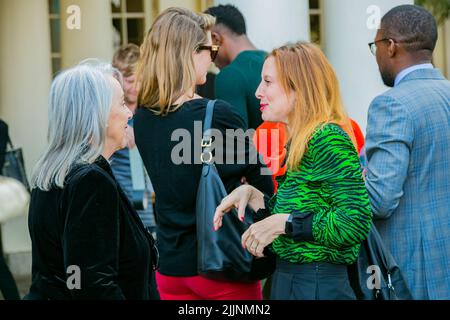 VIP guests mingling and talking at an outdoor social event in ...