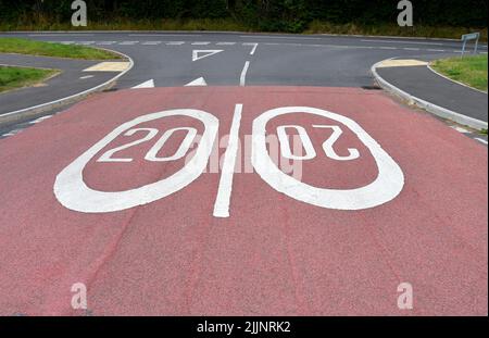 Road markings showing a 20 mph speed limit at the approach to a ...