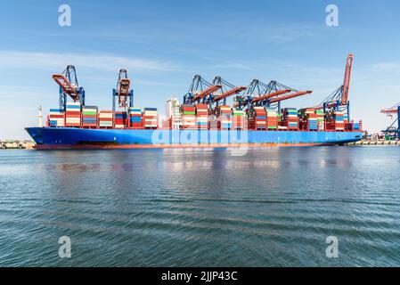 Container vessel equipped with ship cranes during cargo operation ...