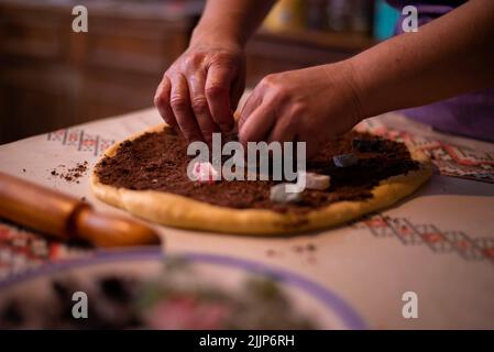 A housewife adding filling to the dough Stock Photo - Alamy
