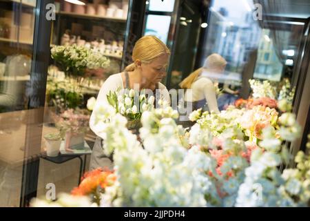 flower shop manager checks the quality of products in the refrigerator ...