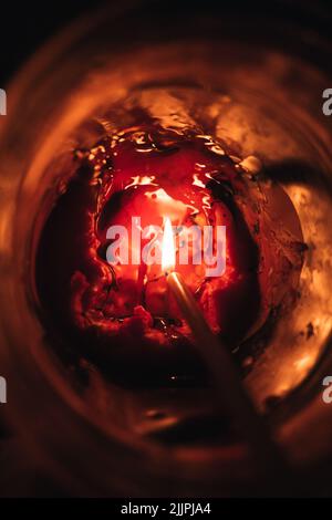Red candle flame closeup. Bright burning fire of candlewick in darkness ...