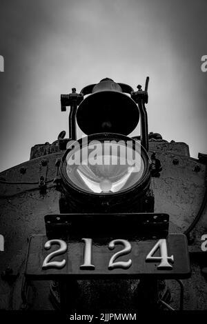 A grayscale of an old and historic steam train on track in a museum ...