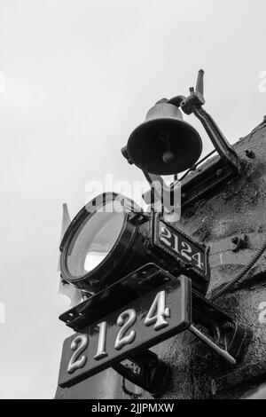 A grayscale of an old and historic steam train on track in a museum ...