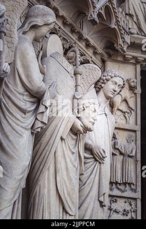 Saint Denis without head and angel, Notre dame detail, Paris, France ...