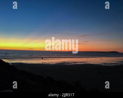 sunset on the sea, sunset and night at the same time, rocks and sand in ...