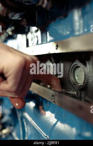 A vertical closeup shot of a mechanic mounting the car engine Stock ...