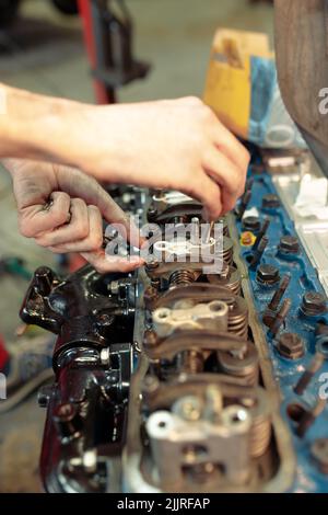 A vertical closeup shot of a mechanic mounting the car engine Stock ...