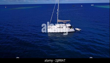 A beautiful shot of a yacht sailing across a deep blue ocean with other ...