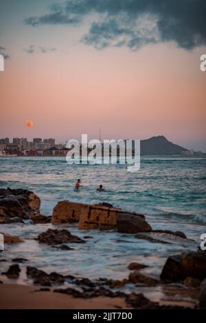 A vertical shot of a rocky beach against a sea covered with fog Stock ...