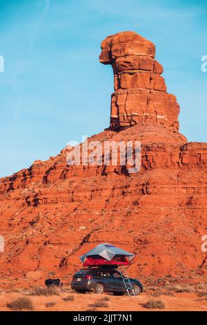 A vertical shot of a car with a roof tent in front of the Castleton ...