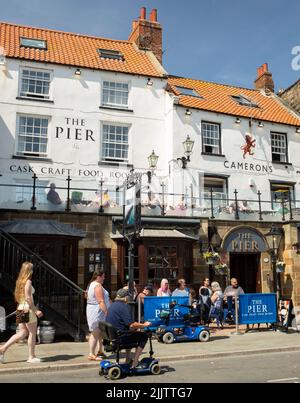 The Pier Pub by the harbour Whitby England UK very busy on a summer ...