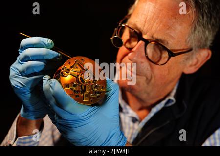 Horologist Jonathan Betts services a Louis XVI ormolu Cartel clock ...