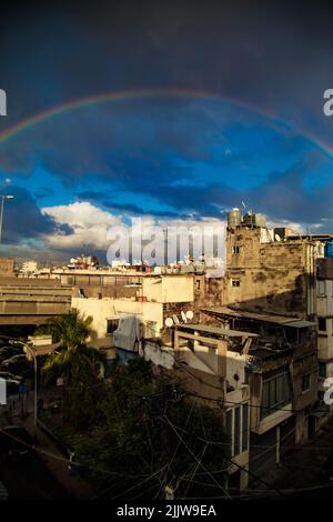 A beautiful shot of a rainbow over the buildings Stock Photo - Alamy