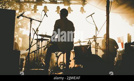 Drummer performing on stage at concert Stock Photo - Alamy