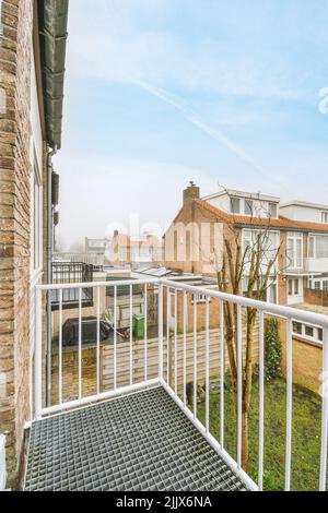 Views of multiple houses and backyard from metal balcony under cloudy ...