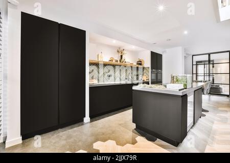 Counter with black cupboards and modern built in appliances placed in ...