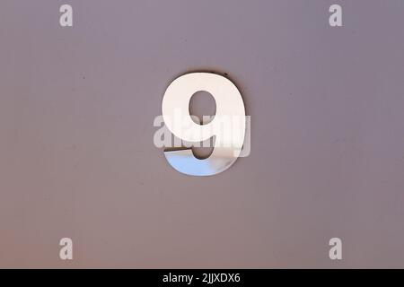 number nine in metallic plate format, with copy space and blue and ...